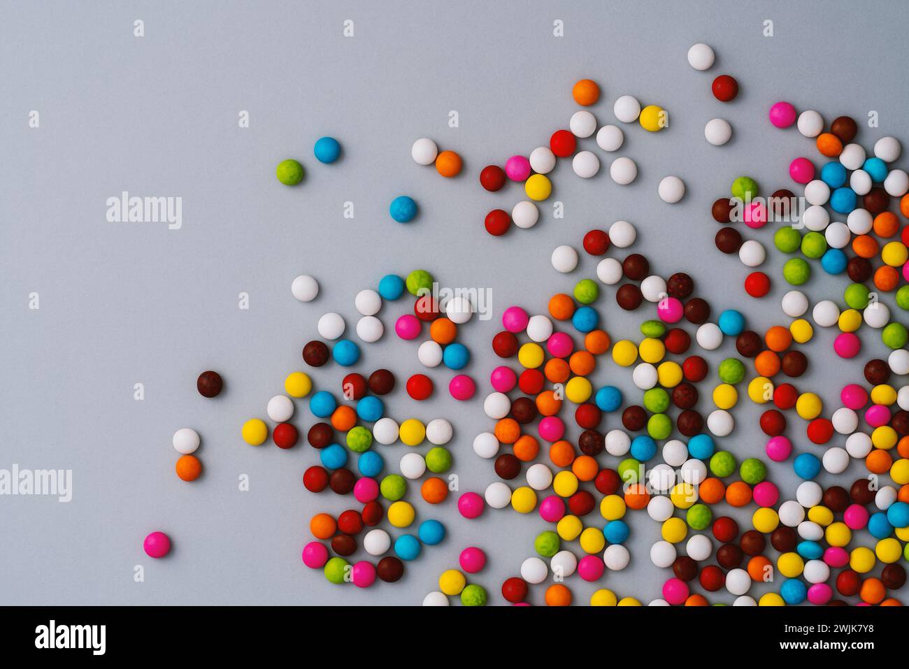 Colorful chocolate bean candies on grey background. Directly above ...
