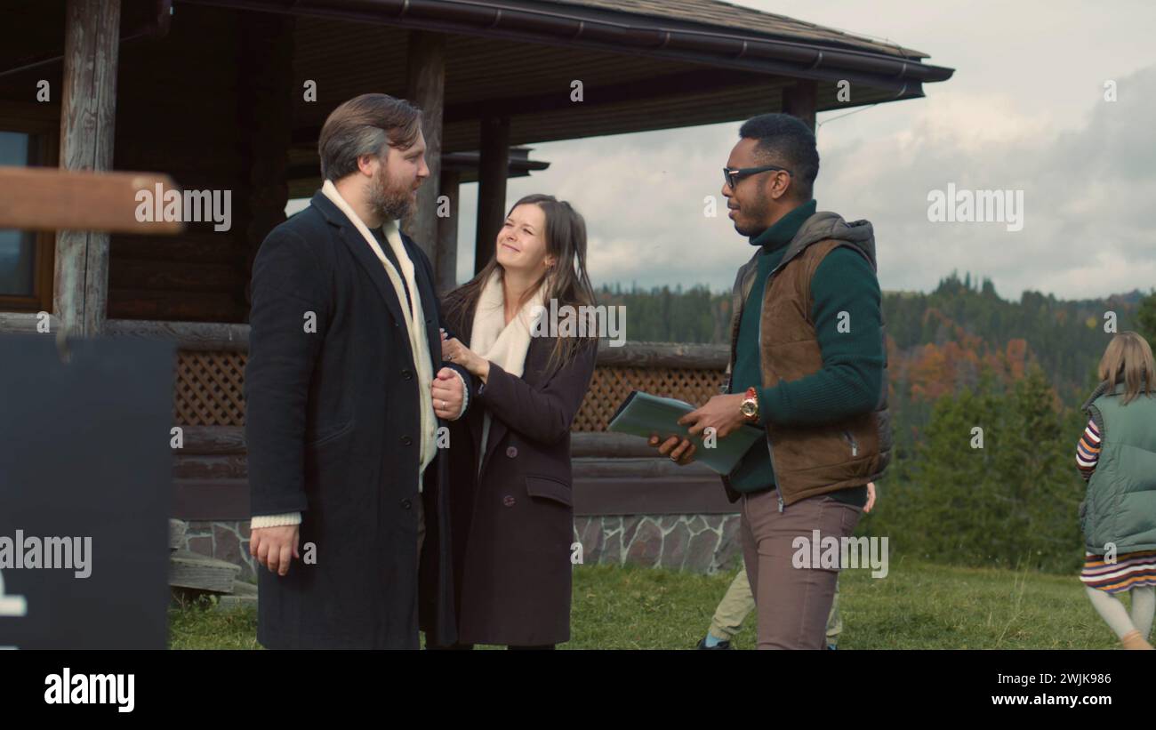 African American real estate agent puts sold sticker on for sale sign ...