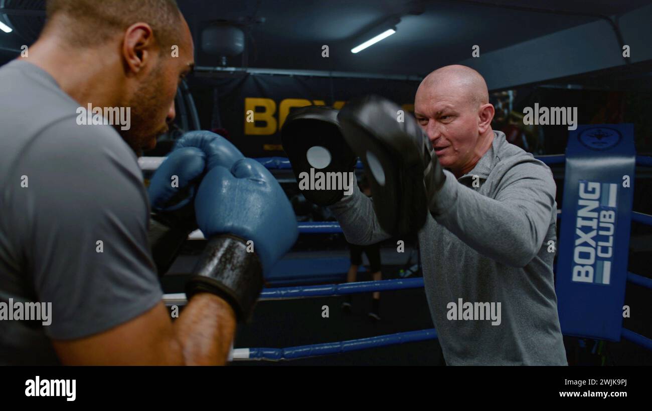 African American professional boxer in boxing gloves exercises with ...