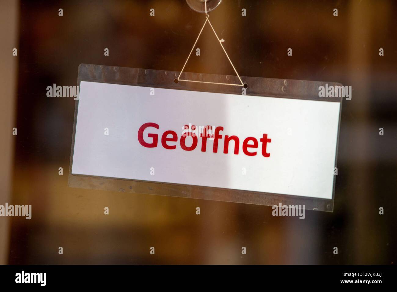 Schild mit dem Hinweis GEÖFFNET an einer Schaufensterscheibe *** Sign ...