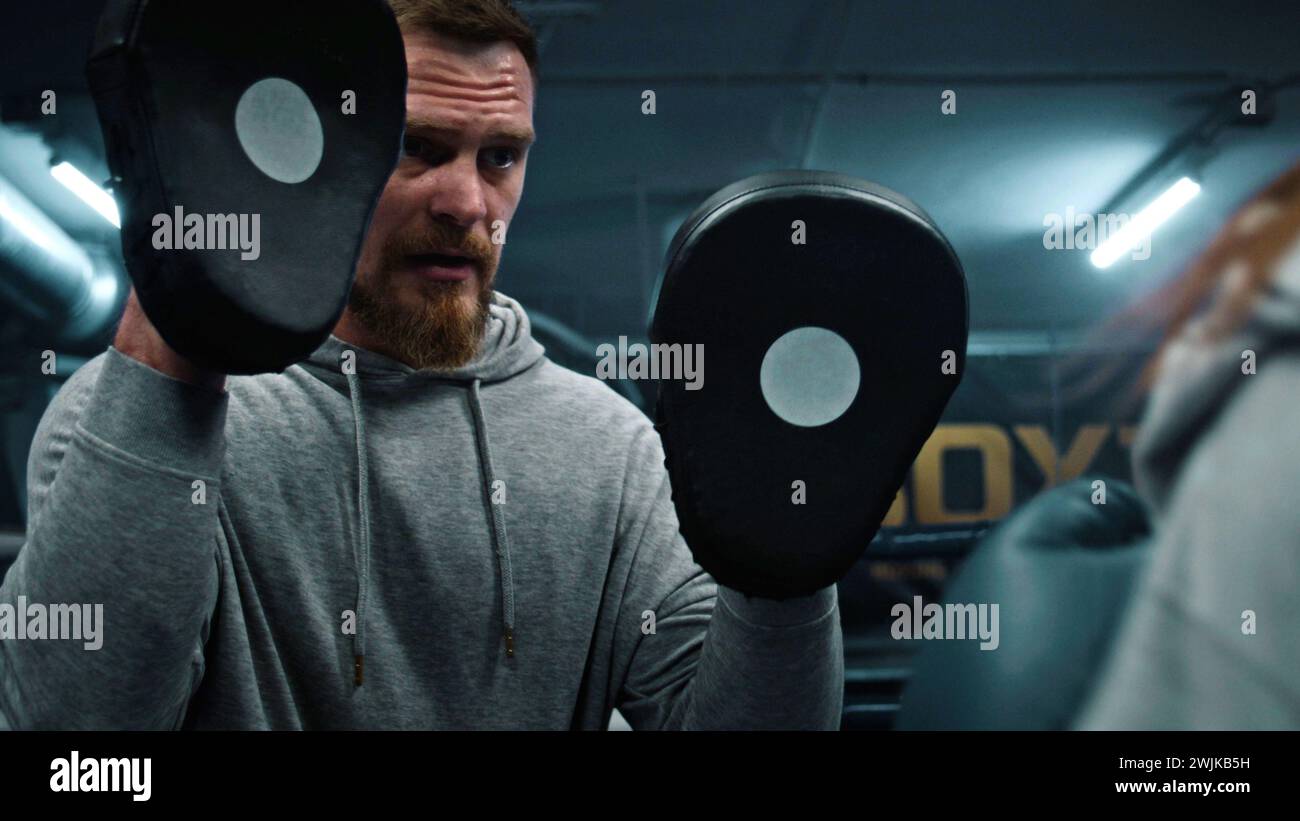 Close up of female boxer hitting punching mitts while training on ...