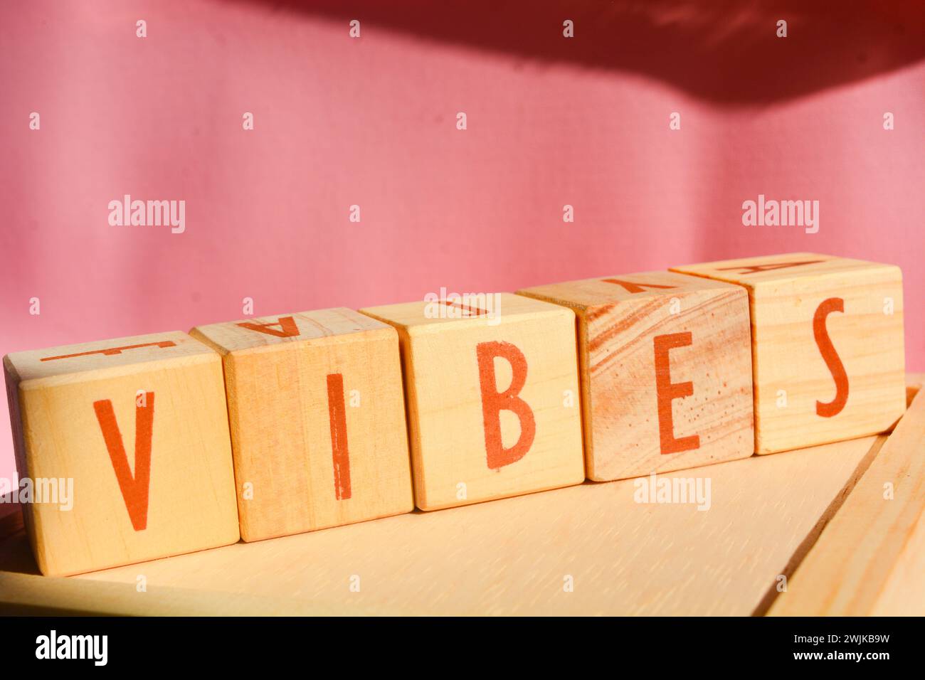 English vocabulary "VIBES" with medium brown wooden blocks, pink and ...