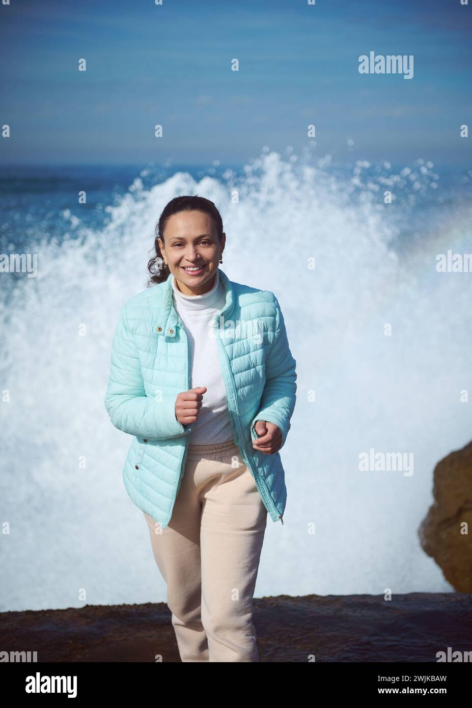 Running woman against huge wave on the Atlantic ocean, People and ...