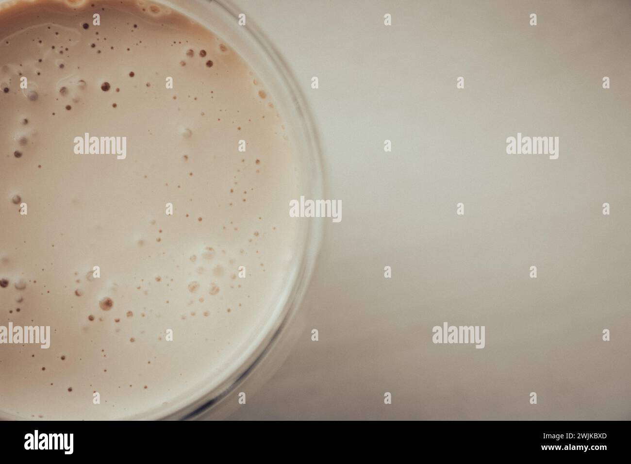 Creamy coffee on beige background with copy space. Milk foam with ...