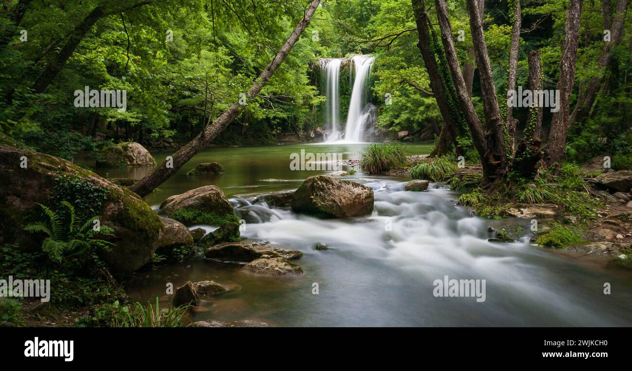 A stunning river cascades gracefully with a picturesque waterfall Stock ...