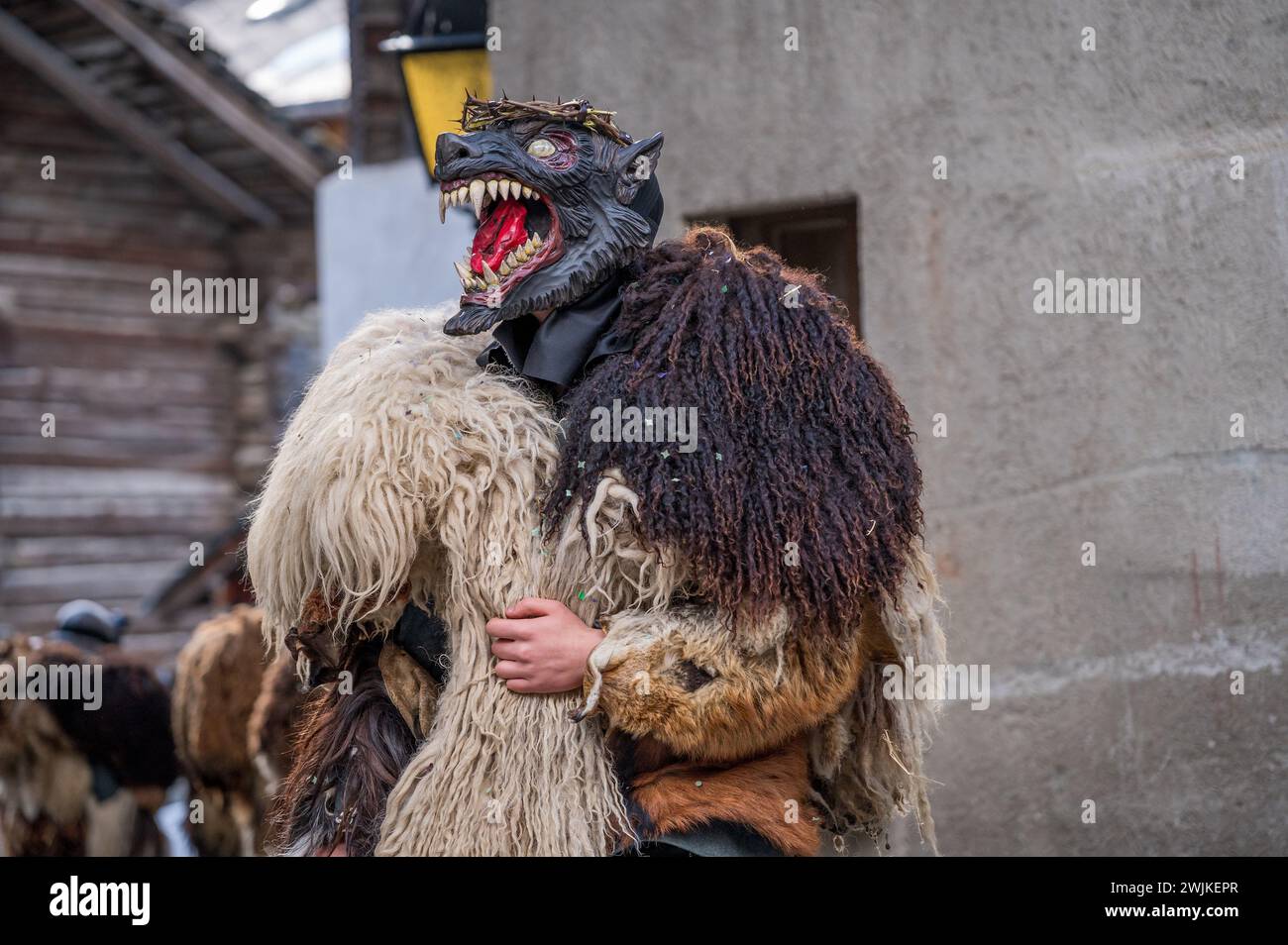 Reveller wearing wooden mask and carnival costume. Evolene, Valais ...