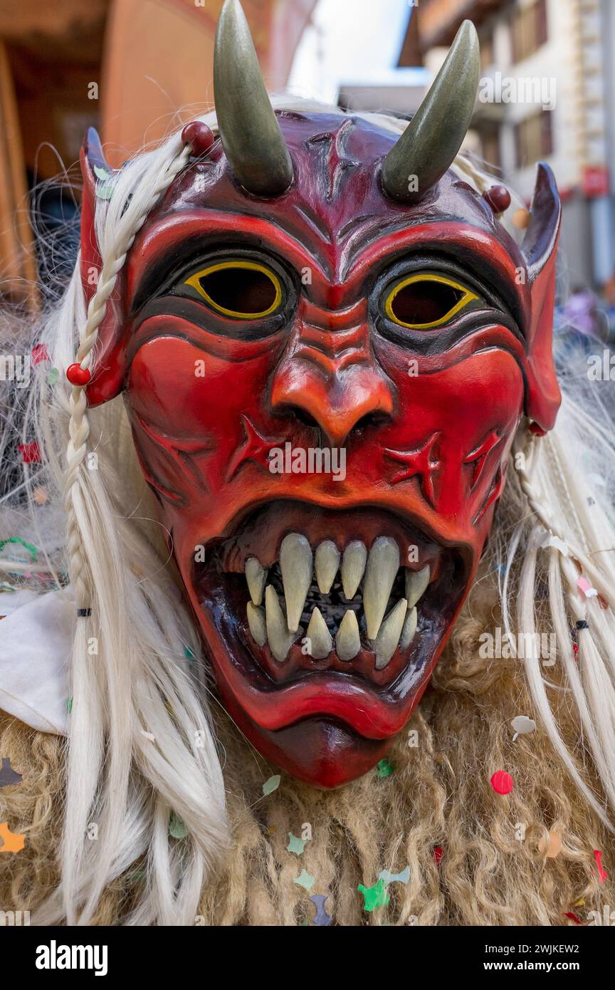 Reveller wearing wooden mask and carnival costume. Evolene, Valais ...