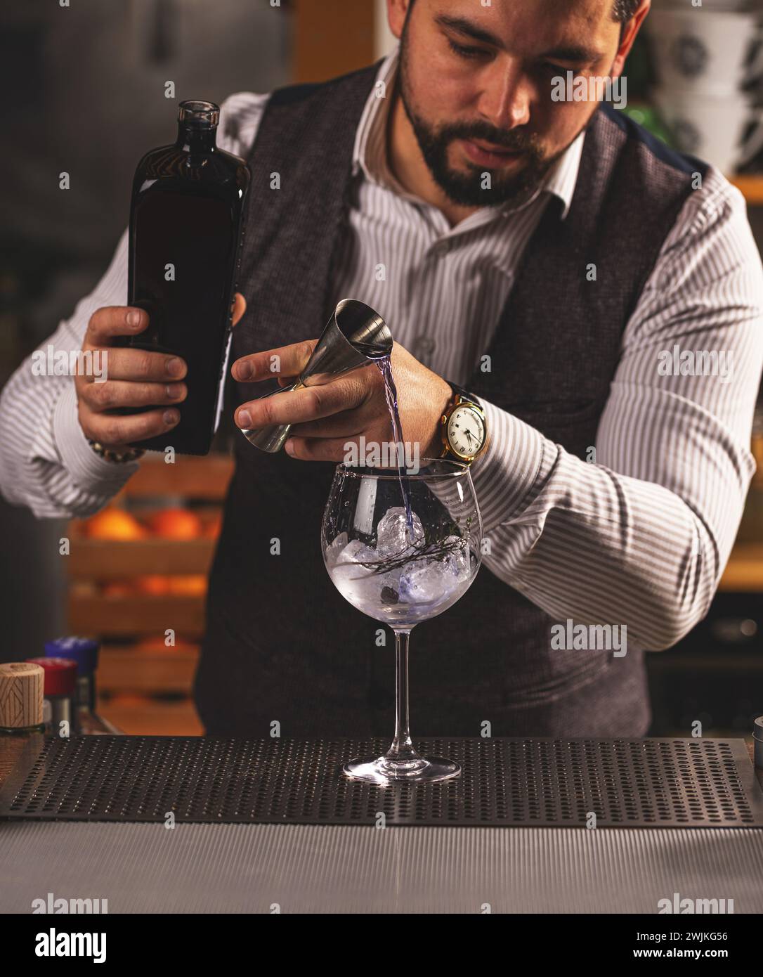 Bartender preparing cocktail, measuring alcohol with jigger on bar counter Stock Photo - Alamy