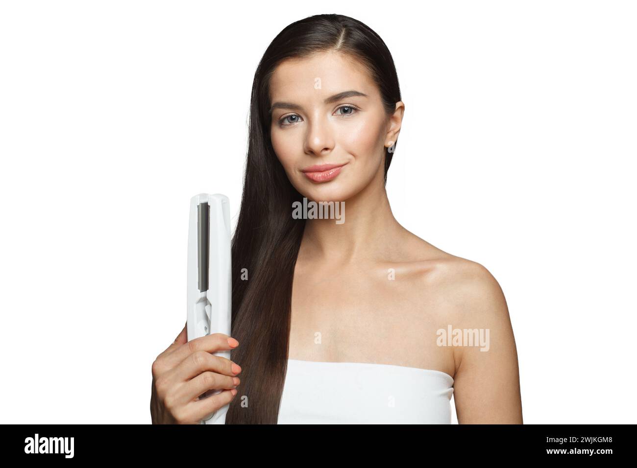 Fashion model woman holding hair iron and straightening her healthy ...