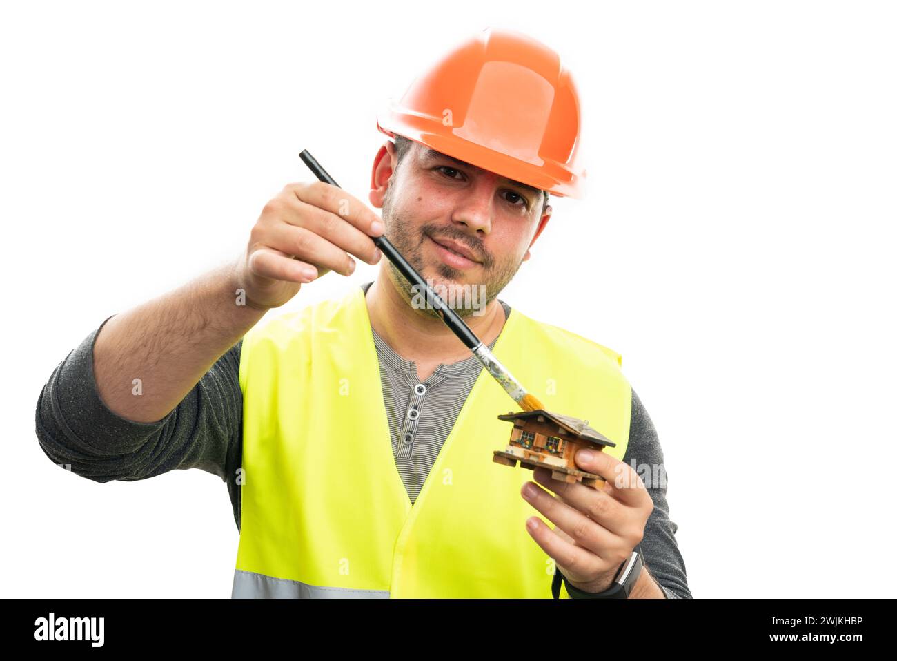 Constructor man wearing orange helmet and fluorescent vest painting ...
