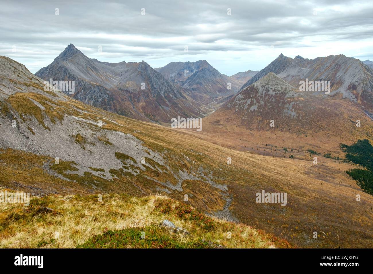 The rugged landscape showcases jagged mountain peaks piercing the sky ...
