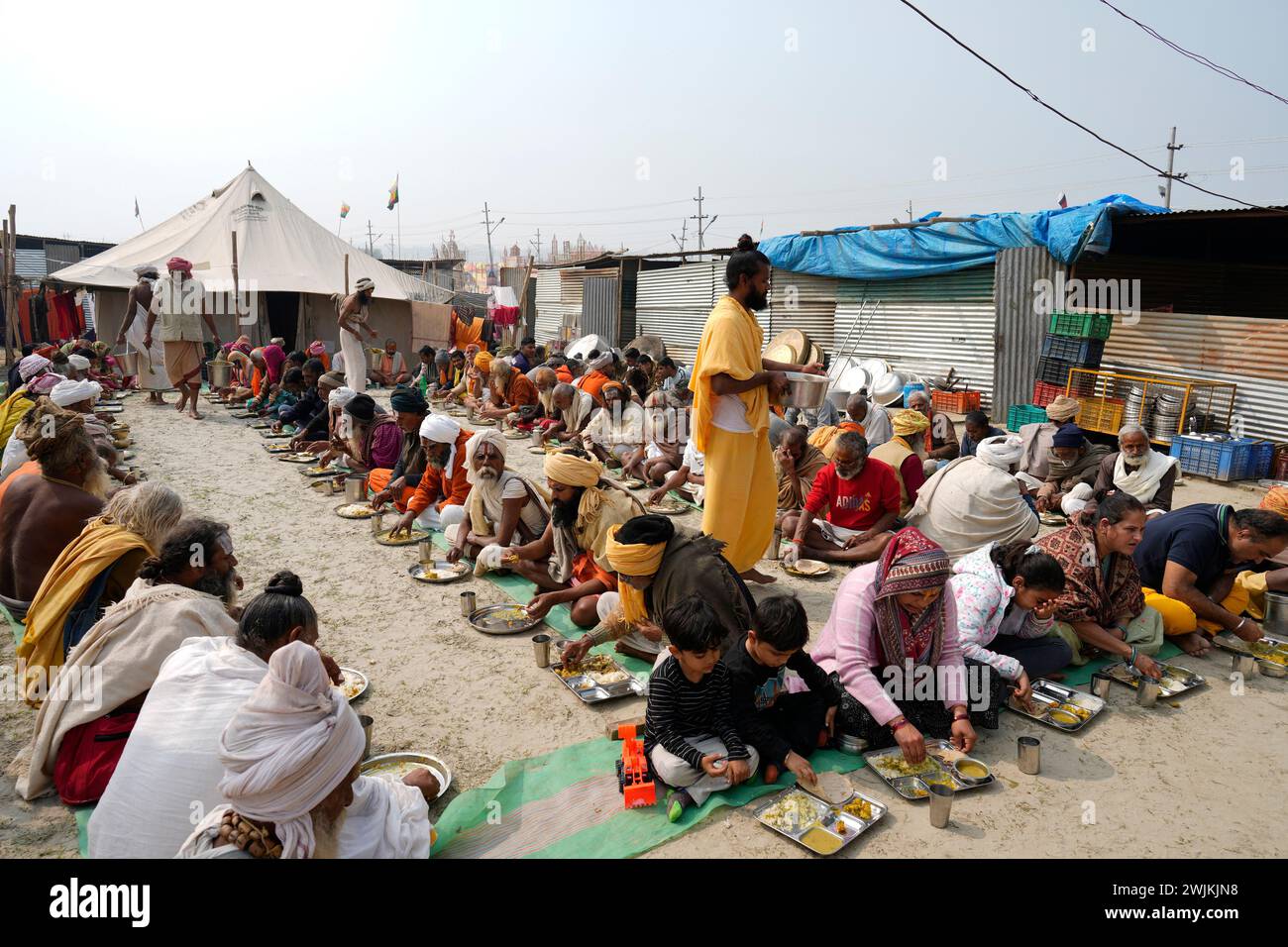Hindu devotees participate in a community feast at the Sangam, the ...
