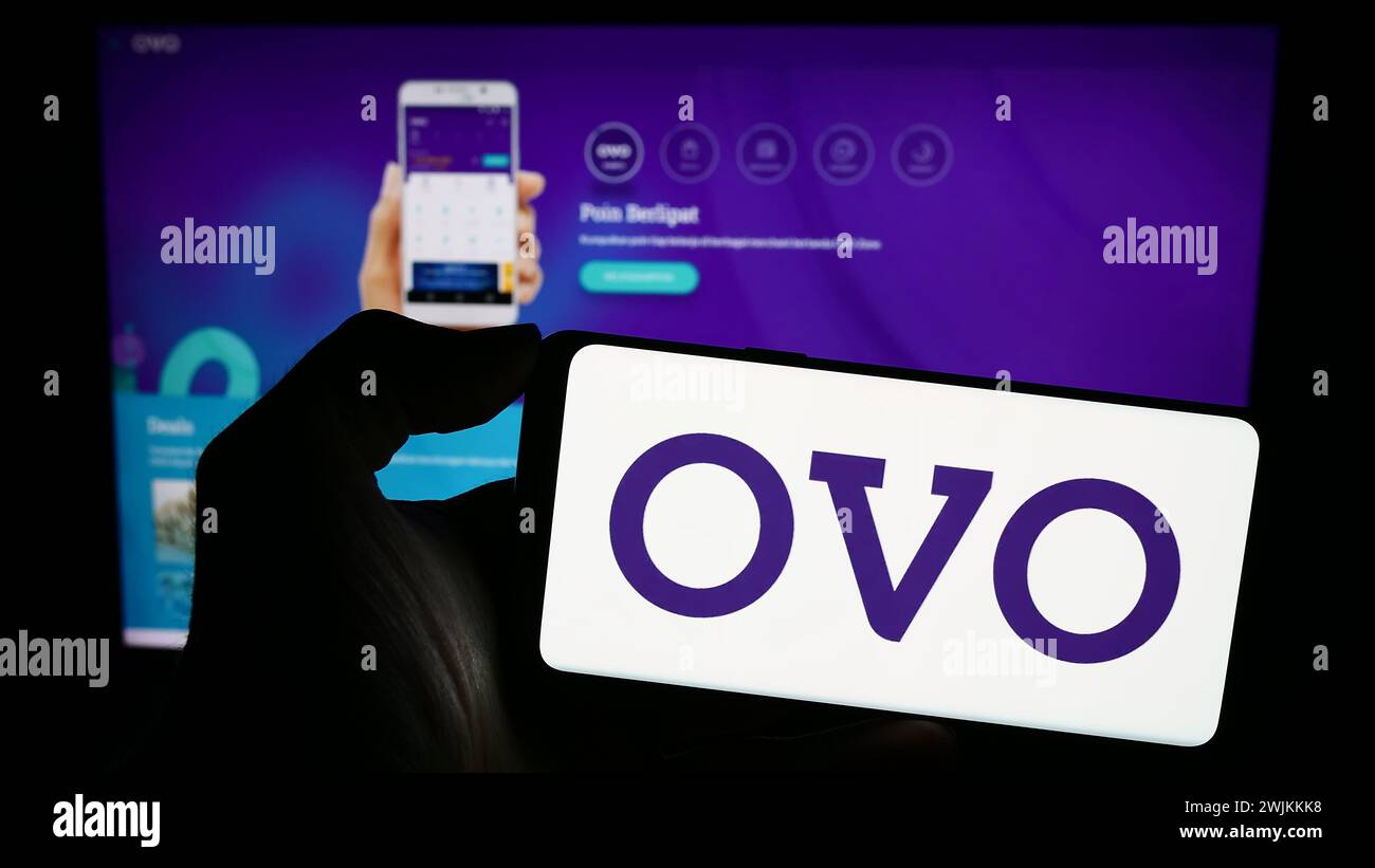 Person holding mobile phone with logo of Indonesian payment company OVO ...