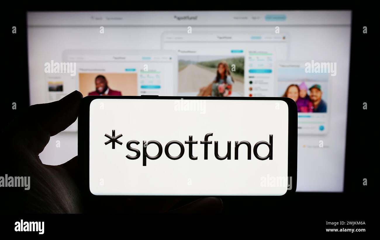 Person holding mobile phone with logo of US crowdfunding company Spotfund Technologies Inc. in ...