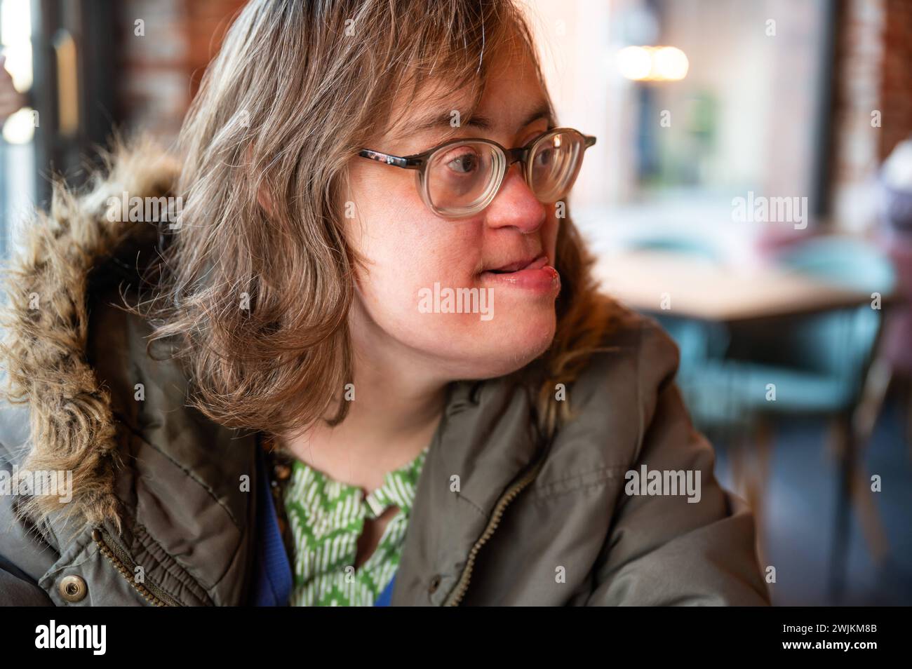 Happy woman with the Down Syndrome looking away, indoor portrait ...
