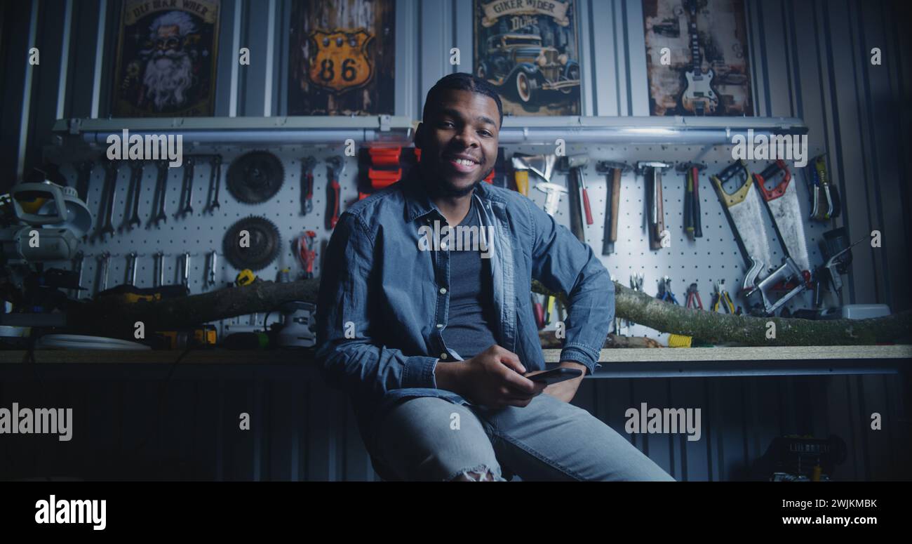 African American carpenter, craftsman uses mobile phone, smiles and ...