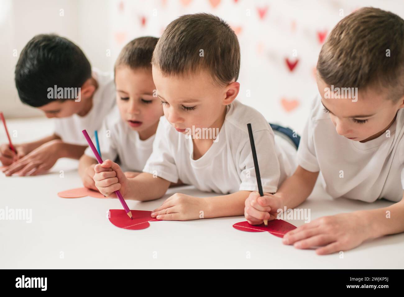 Kids writing with colored pencils on cards for Valentine's Day Stock ...