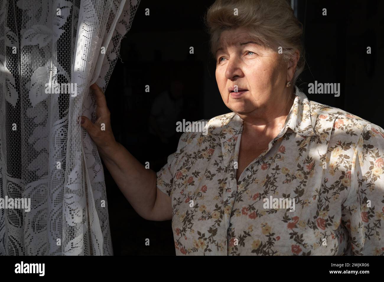 an elderly woman stands at the window.portrait, active old age Stock ...