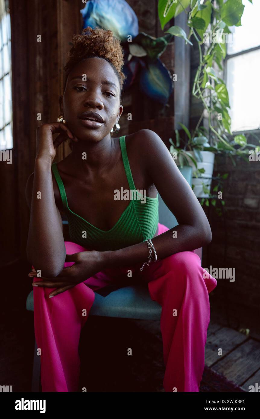 Sitting model leans forward while resting arms on knees Stock Photo - Alamy