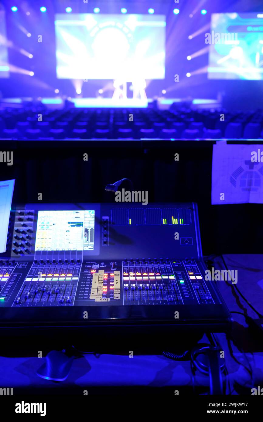 Backstage area at a convention with technical staff handling light and ...