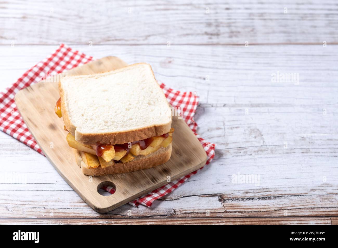 Traditional British chip butty (french fry sandwich) on wooden table ...