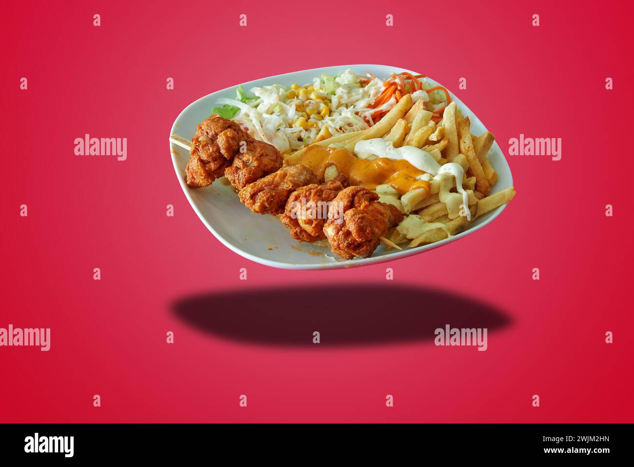Floating plate with Chicken brochette and french fries on red gradient ...