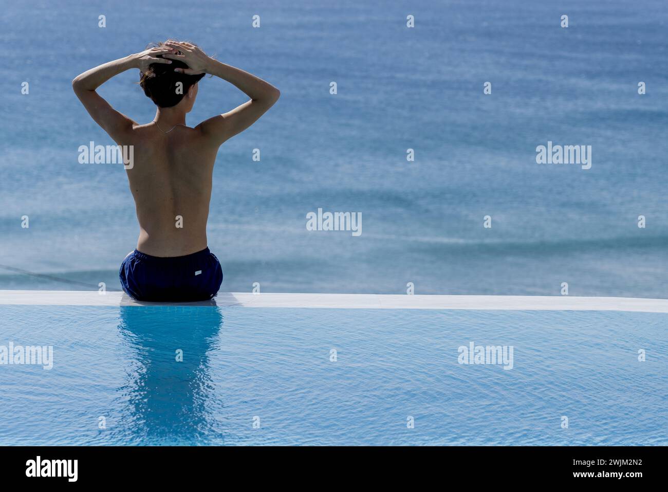 Man sitting on edge swimming hi-res stock photography and images - Alamy