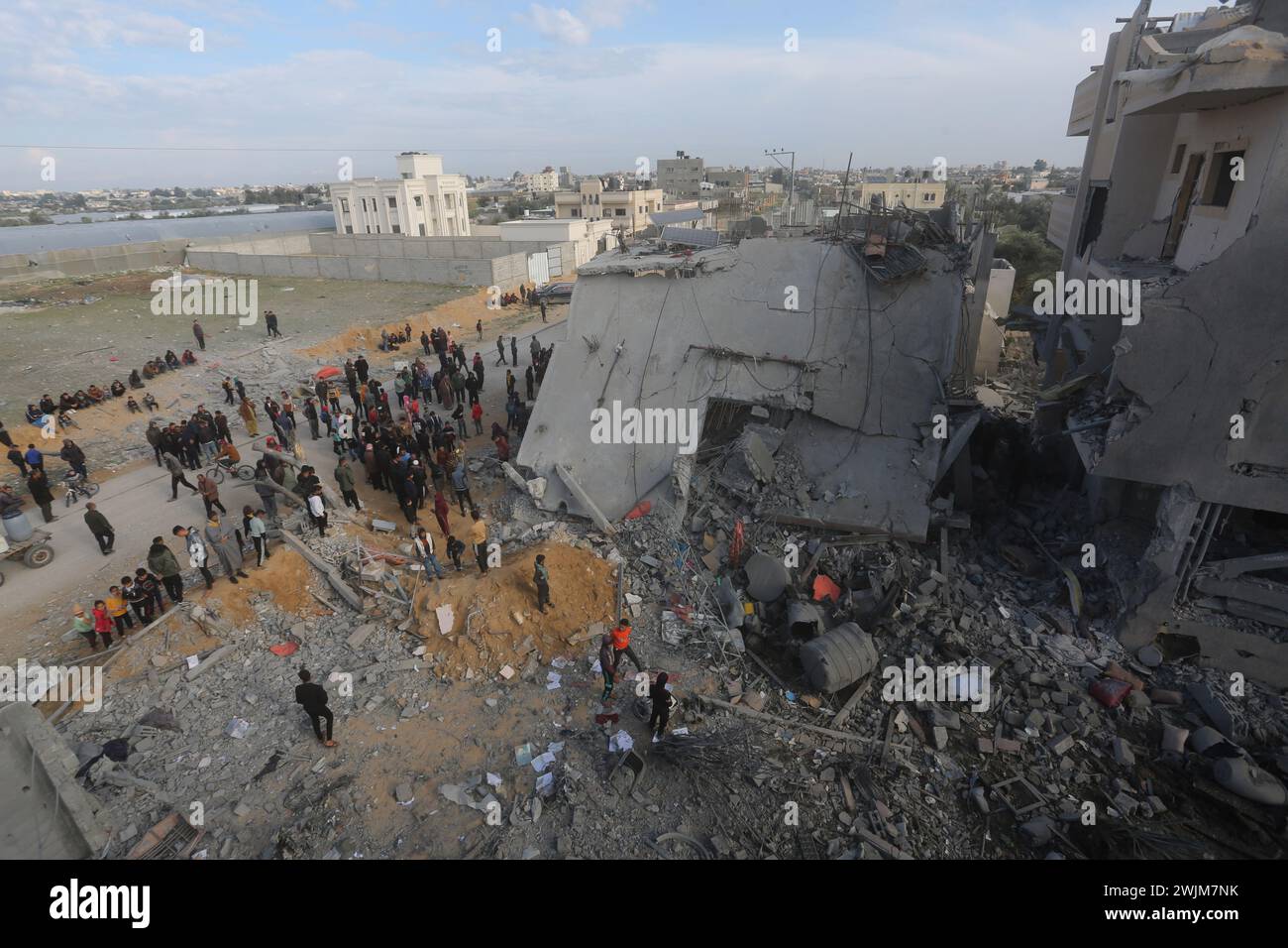 Rafah. 16th Feb, 2024. People check the rubble of a building destroyed ...