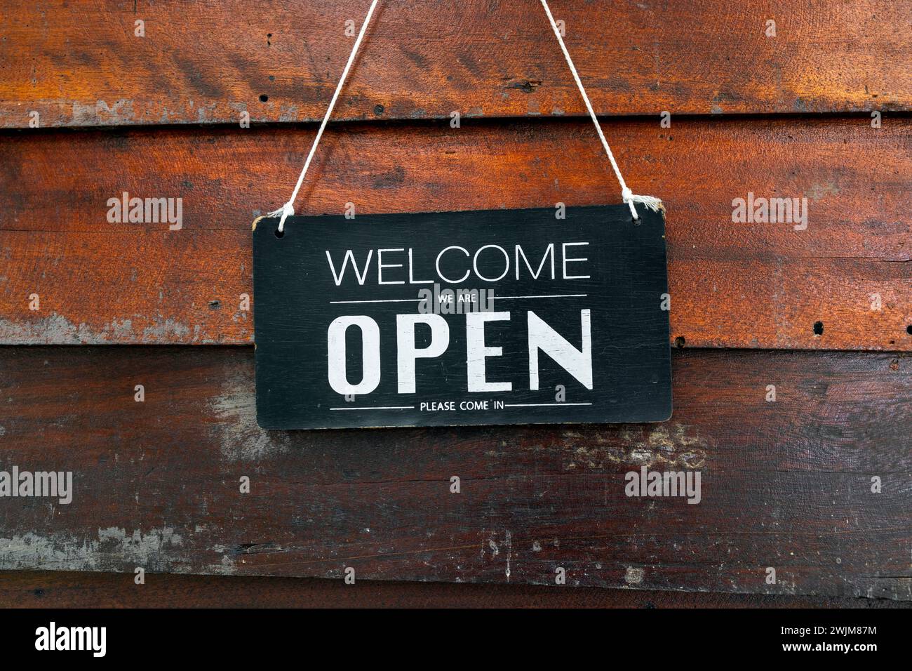 black Wood welcome sign hanging by rope on old wooden background Stock ...