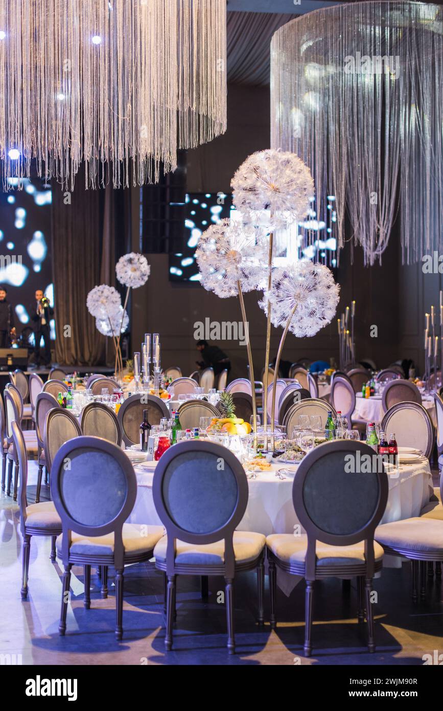 An elegant dinner event set up in front of large windows Stock Photo ...