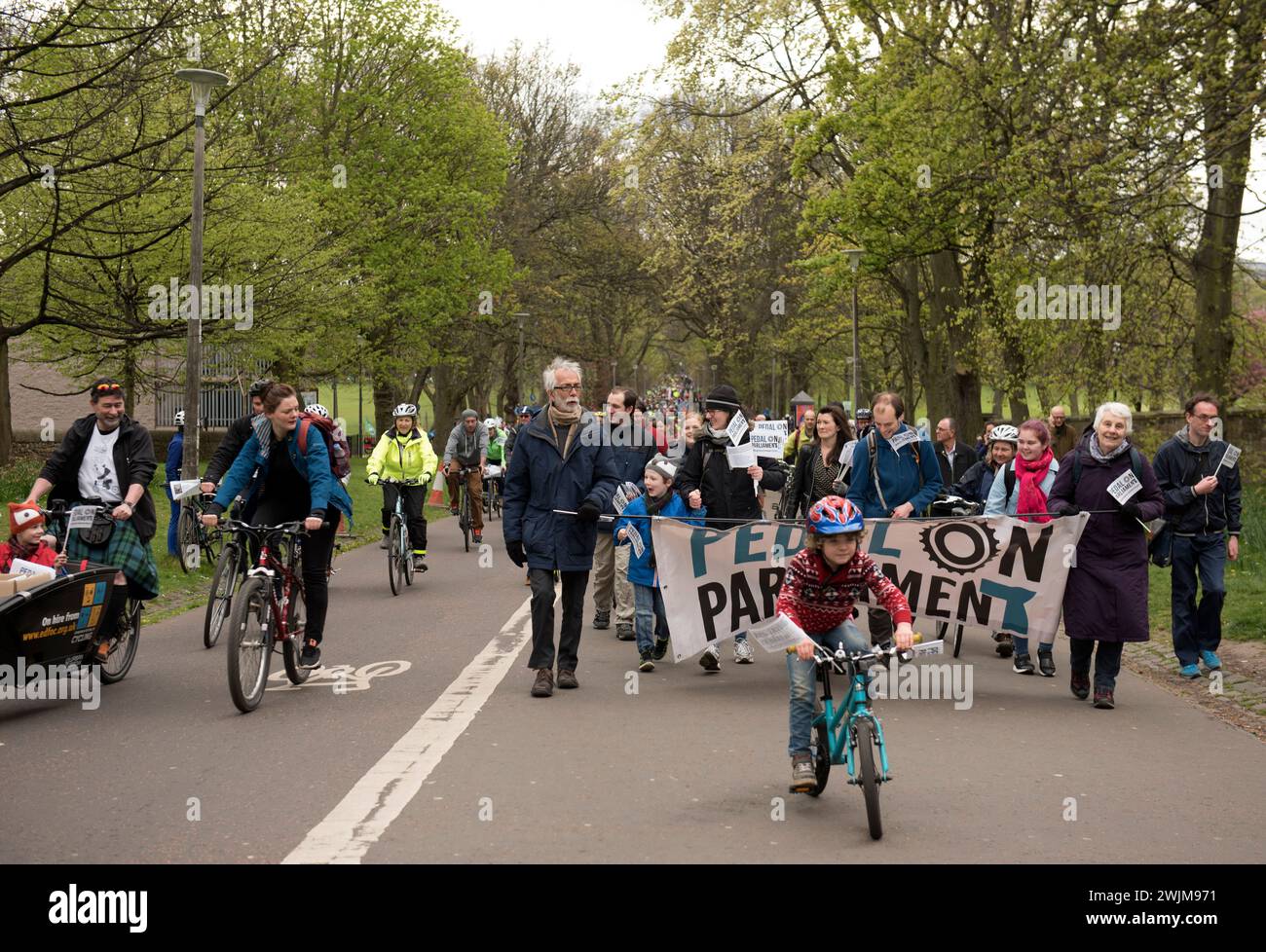Hundreds of cyclists and people with bikes cycle through the streest of ...
