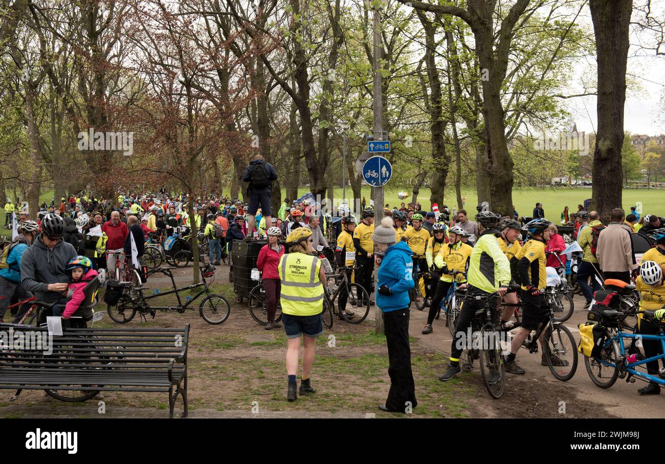 Hundreds of cyclists and people with bikes cycle through the streest of ...
