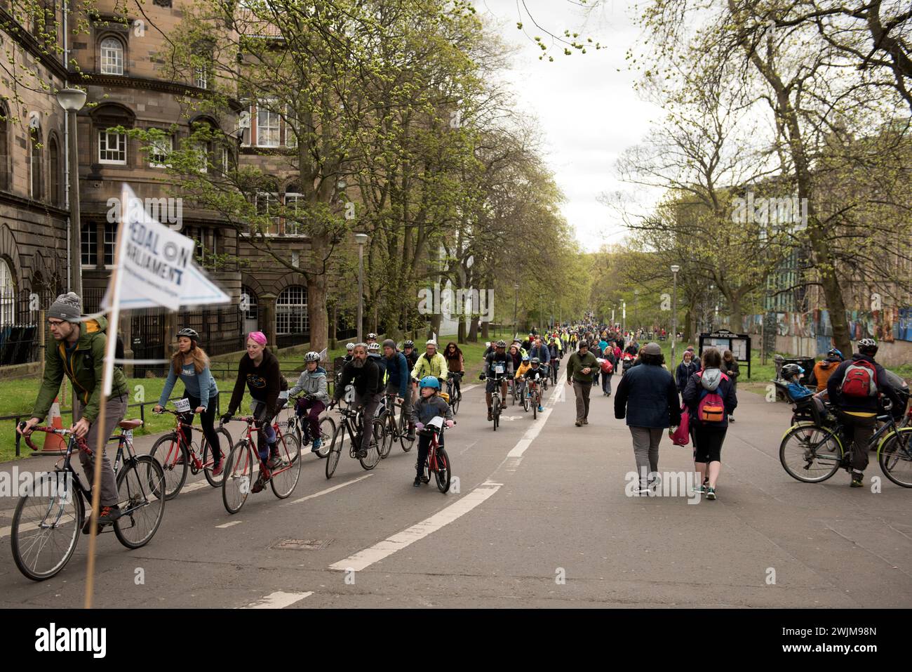 Hundreds of cyclists and people with bikes cycle through the streest of ...