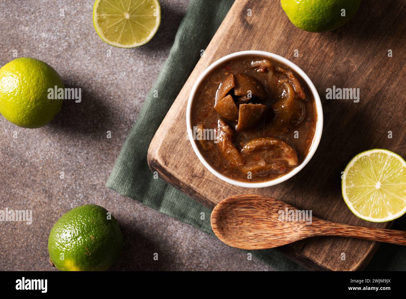 Homemade lime pickle on dark brown background. View from above. Copy ...