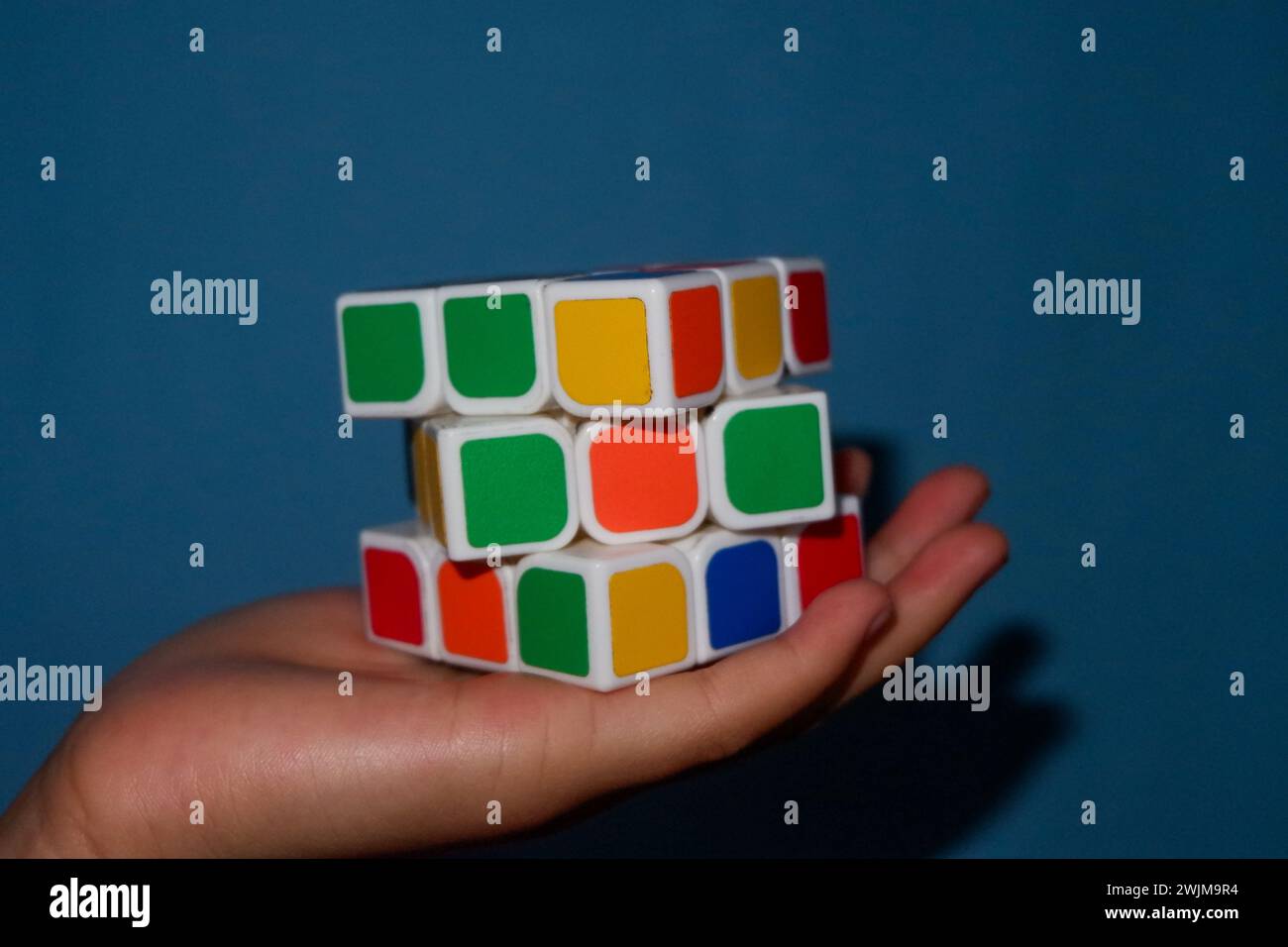 Photo of a person holding a rubik on a light blue background Stock ...