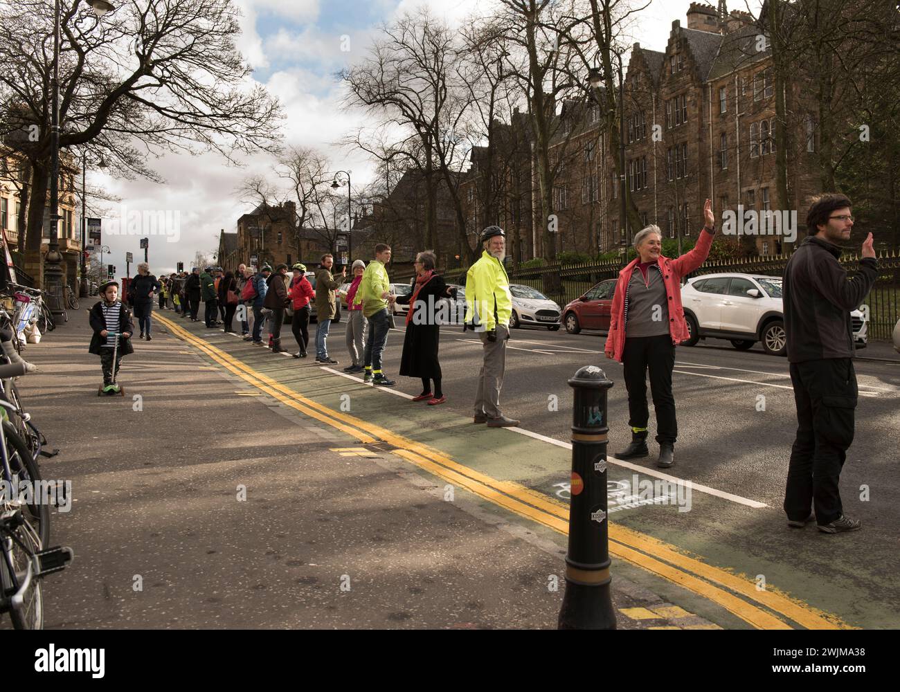 People line a bike lane to make a human bike lane to protest the lack ...