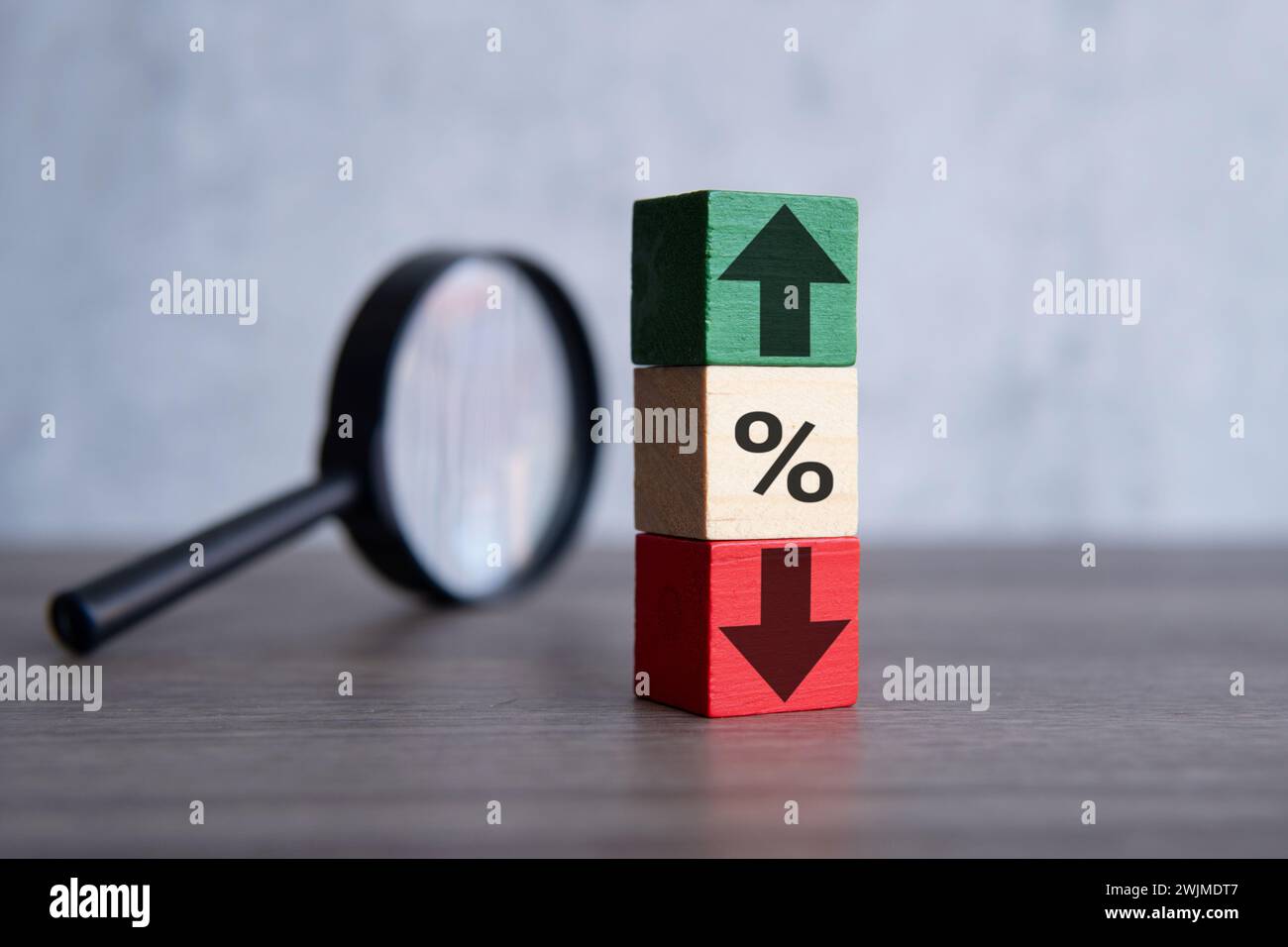 Magnifying glass and wooden blocks with percentage sign, up and down ...