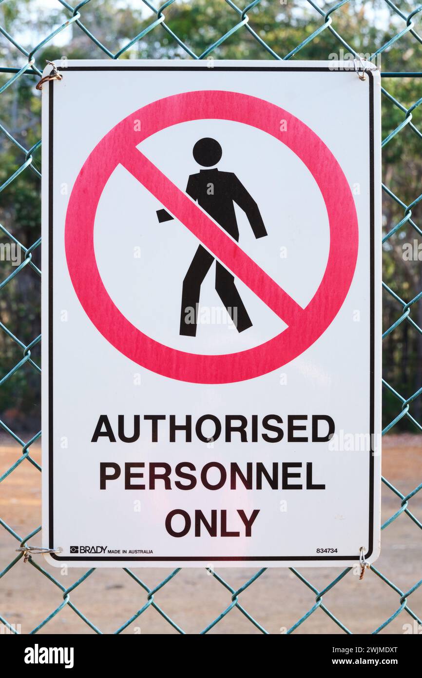 A vertical sign warning attached to a fence indicating Authorised ...