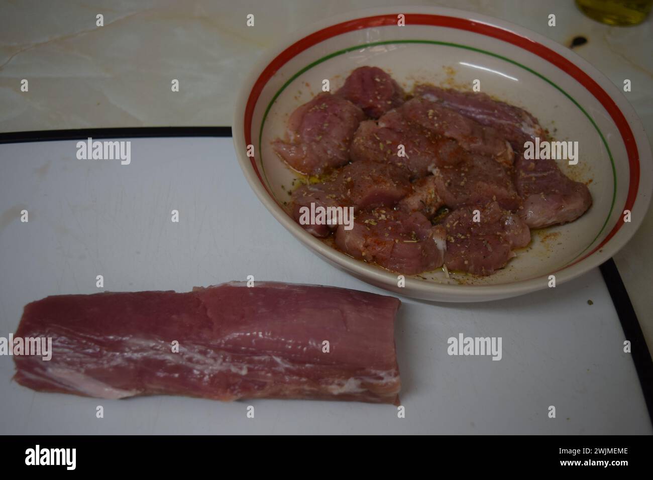Chunks of raw pork tenderloin marinated in a plate bowl,ready to be ...
