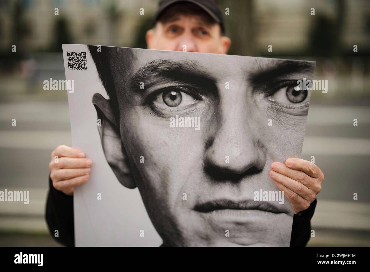 A man holds a poster with a portrait of opposition leader Alexei ...