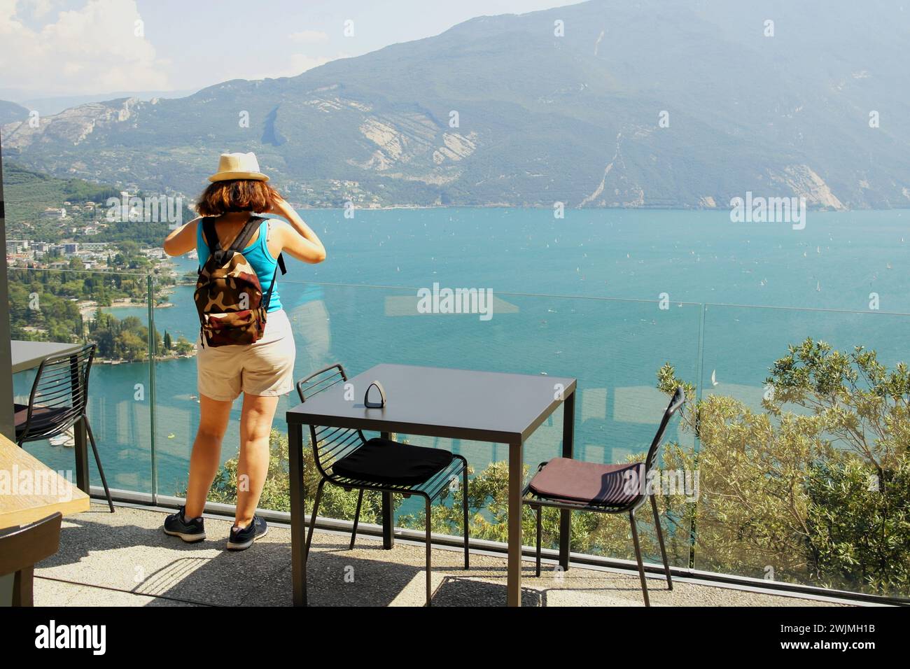 Woman tourist photographing Garda lake from a lookout point, Trentiono ...