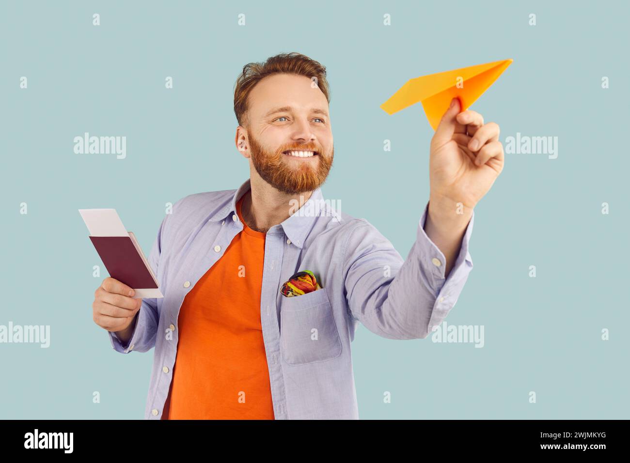 Happy man tossing paper airplane, holding passport with airline ticket ...