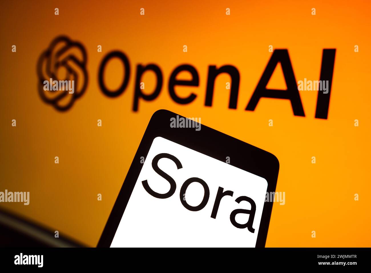 In this photo illustration, the Sora logo is displayed on a smartphone screen and OpenAI logo in ...