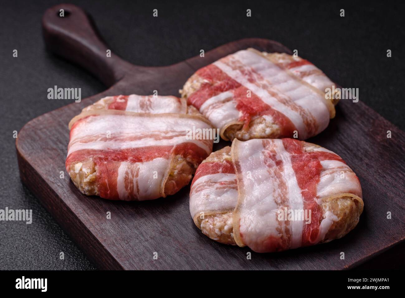 Round minced chicken or pork cutlet wrapped in bacon with salt, spices ...