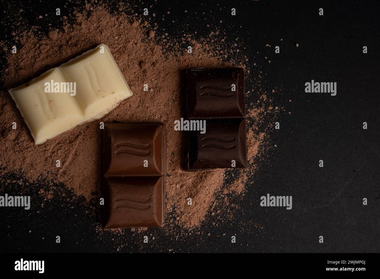 White, dark and milk chocolate in cocoa powder Stock Photo - Alamy