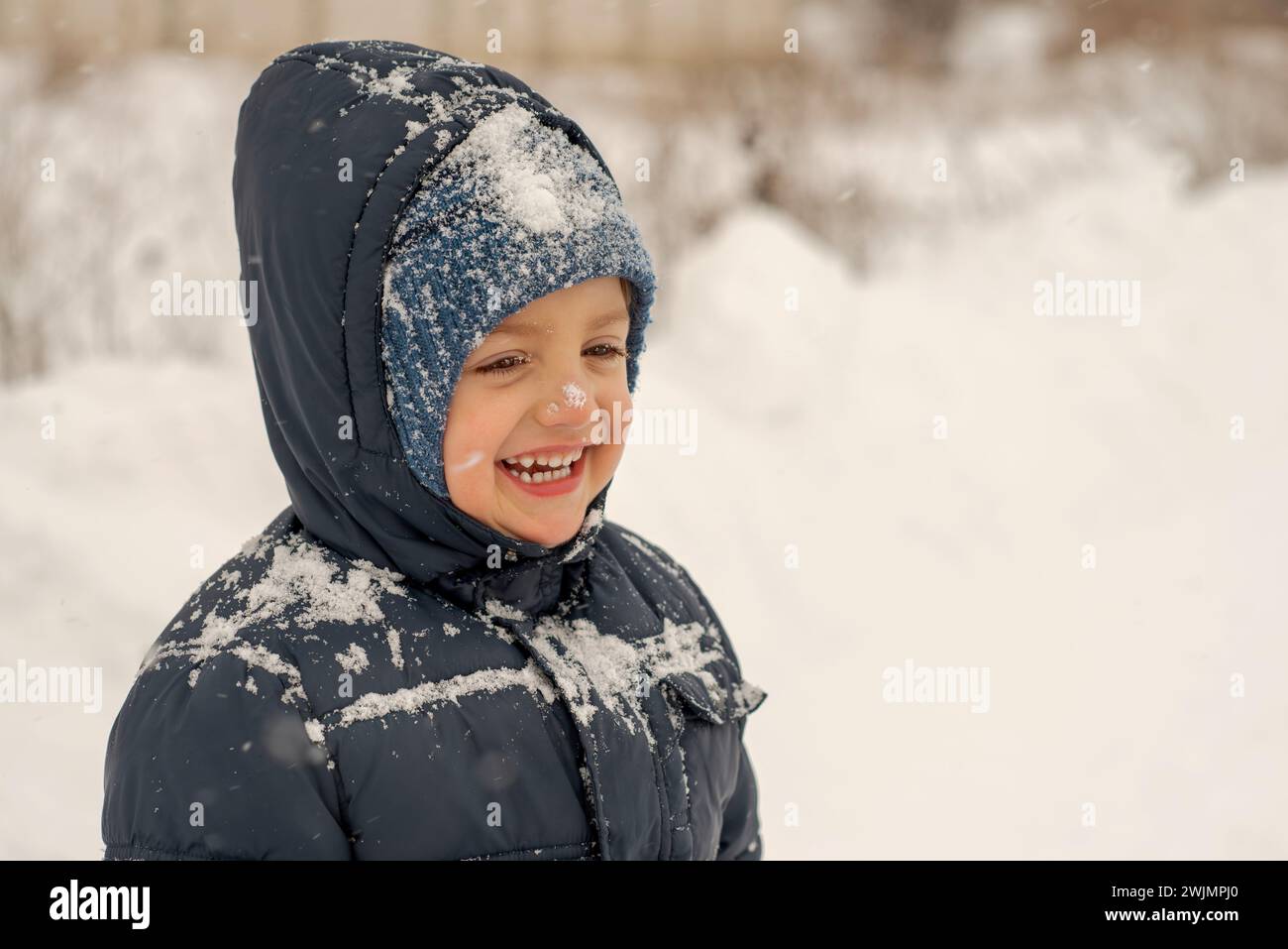 Cute smiling snowy boy enjoying winter season Stock Photo - Alamy