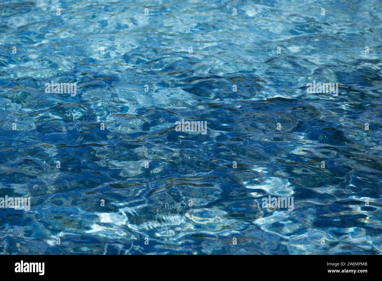 Light and dark blue water in a pool with slightly moving waves and ...