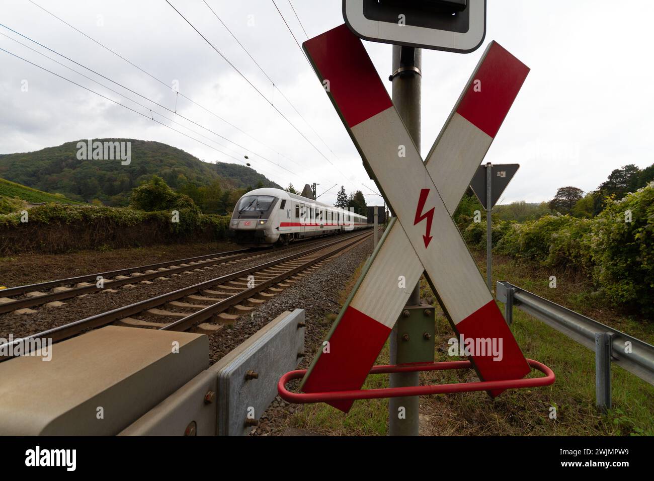 a red warning sign with a passenger train in background Stock Photo - Alamy