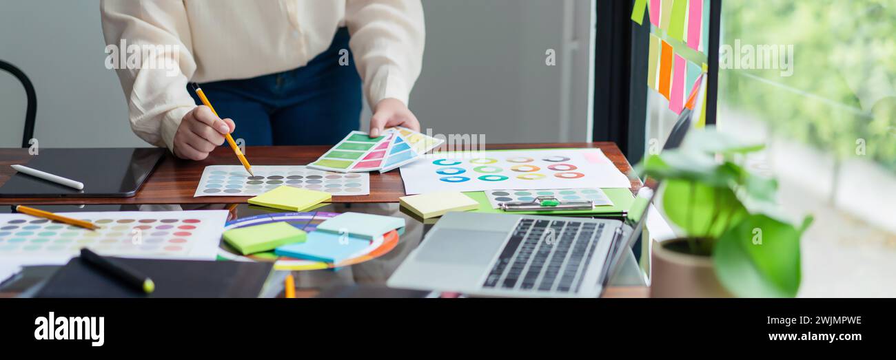 Creative graphic designer holding color sample and comparing color ...