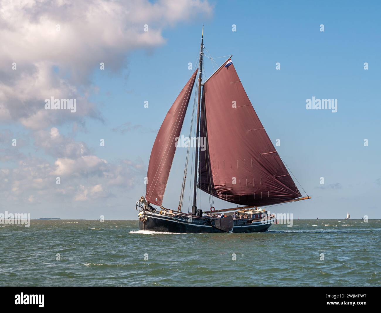 Historic tjalk charter ship sailing on Wadden Sea in the Netherlands ...